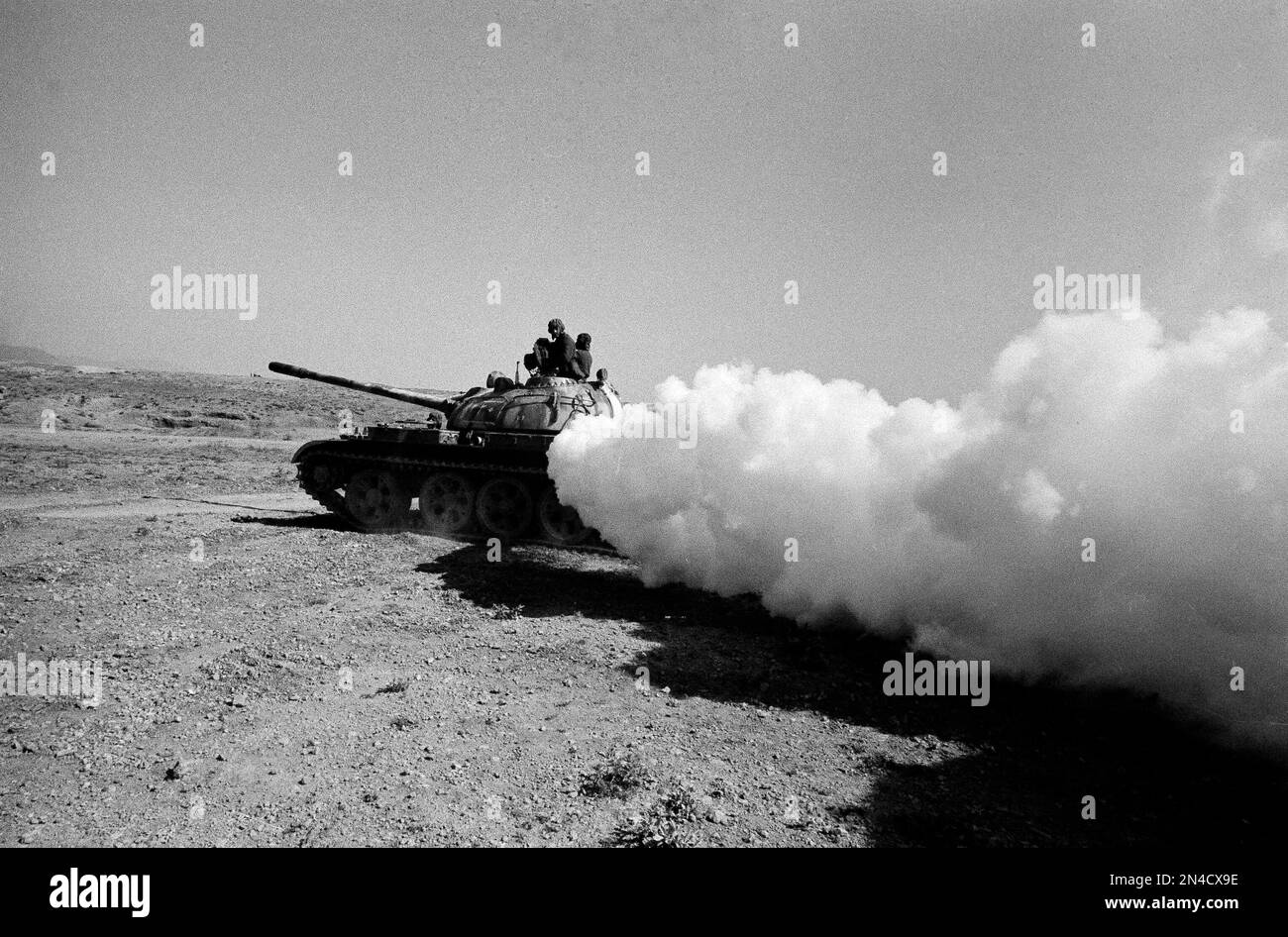 A Soviet-made Syrian T-54 tank throws out a smoke screen as it begins a ...