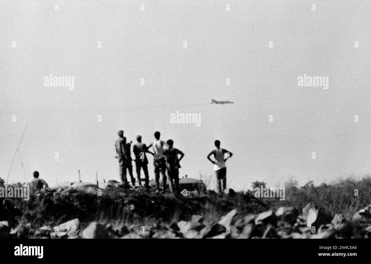 A group of Israeli soldiers watch from high ground as an Israeli air ...