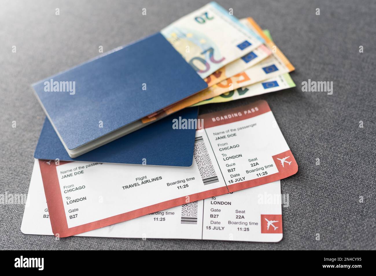 Two blue passports, green boarding pass, flight tickets gray background ...