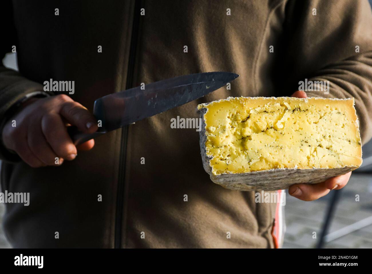A man selling cheese in the market and cutting off a piece Stock Photo ...