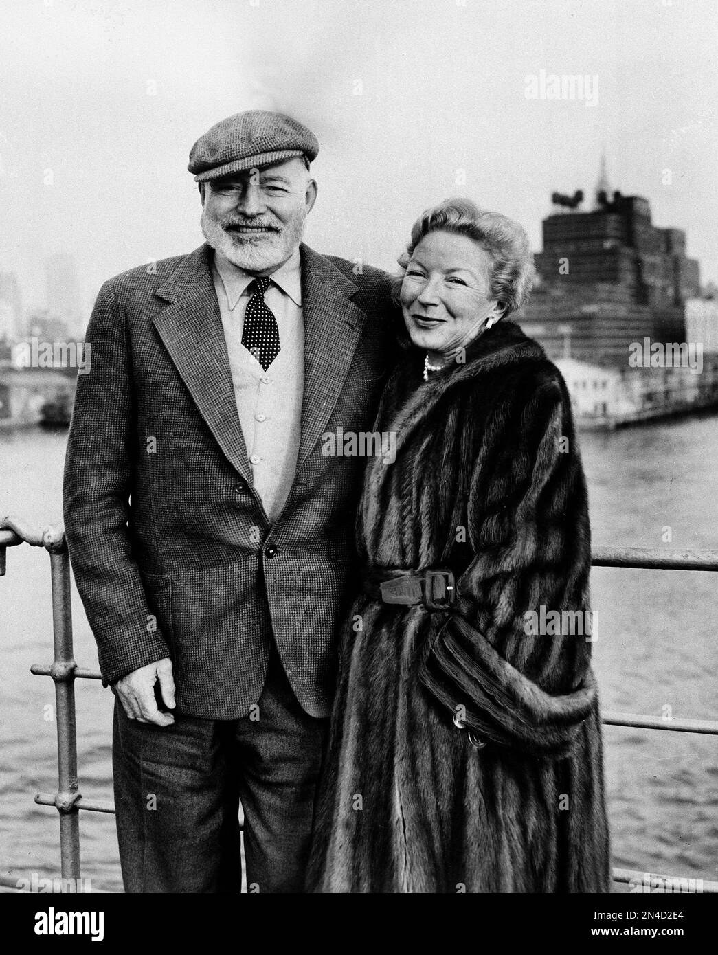 Author Ernest Hemingway and his wife Mary Welsh stand at a rail on the ...