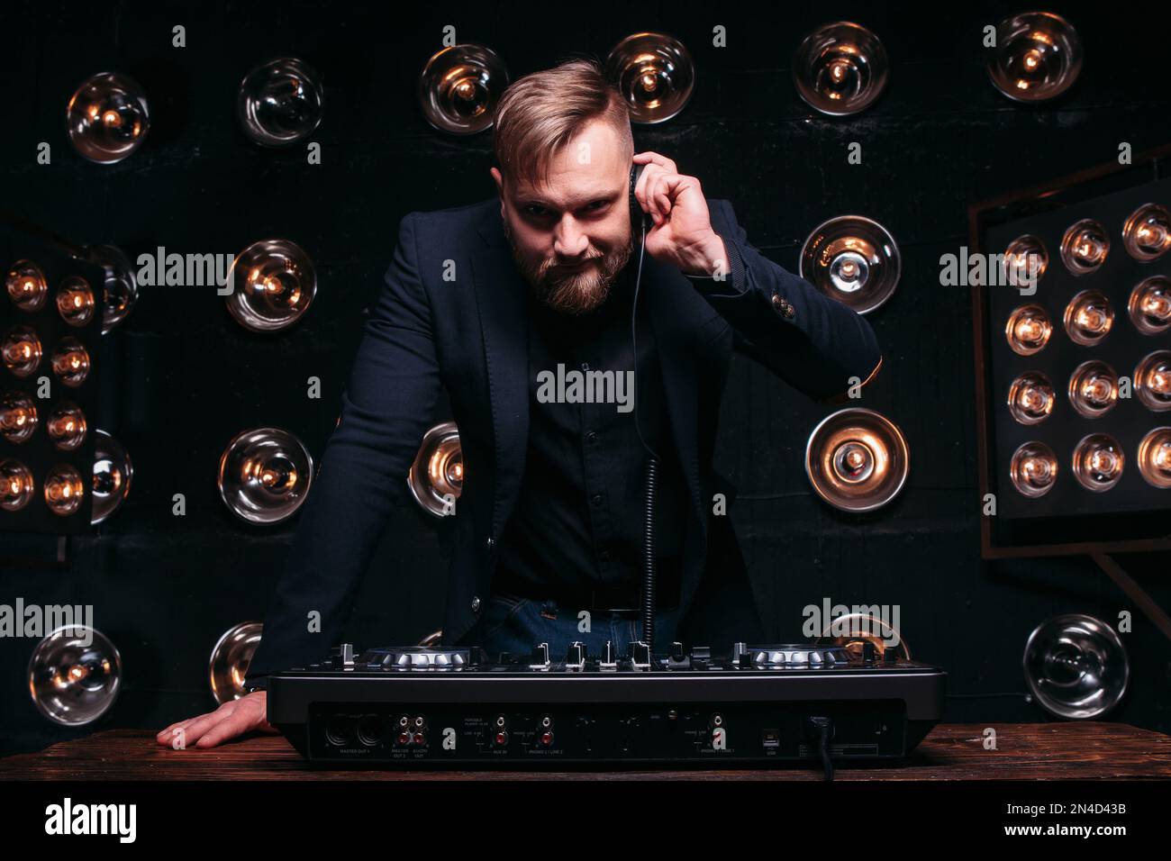 DJ with headphones and mixer checking equipment Stock Photo - Alamy