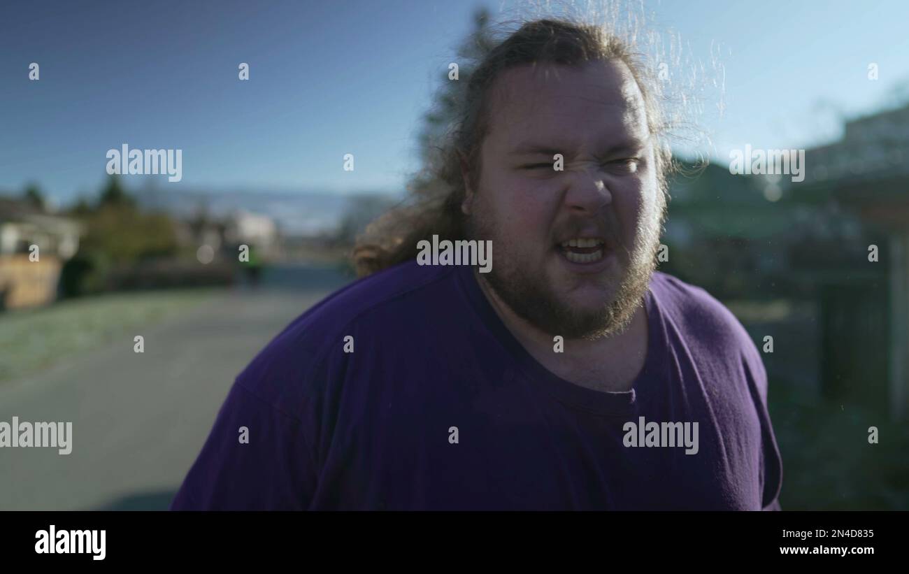 Portrait of an upset angry person walking outside feeling regret for ...