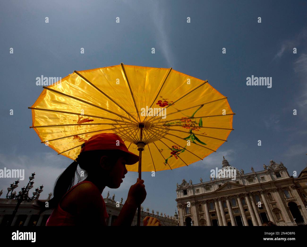 A girl takes shelter from sun with un umbrella as Pope Francis delivers ...