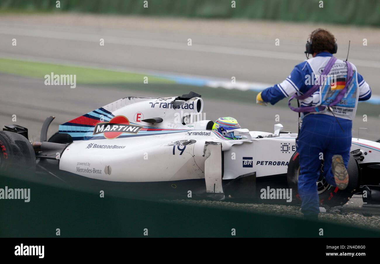 Track marshal runs to Williams driver Felipe Massa of Brazil after he ...