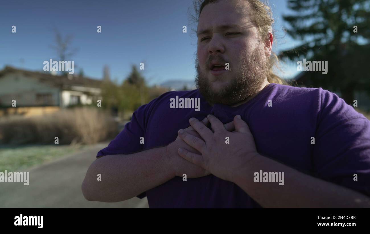 One young fat man having chest pain. Overweight person with panic ...