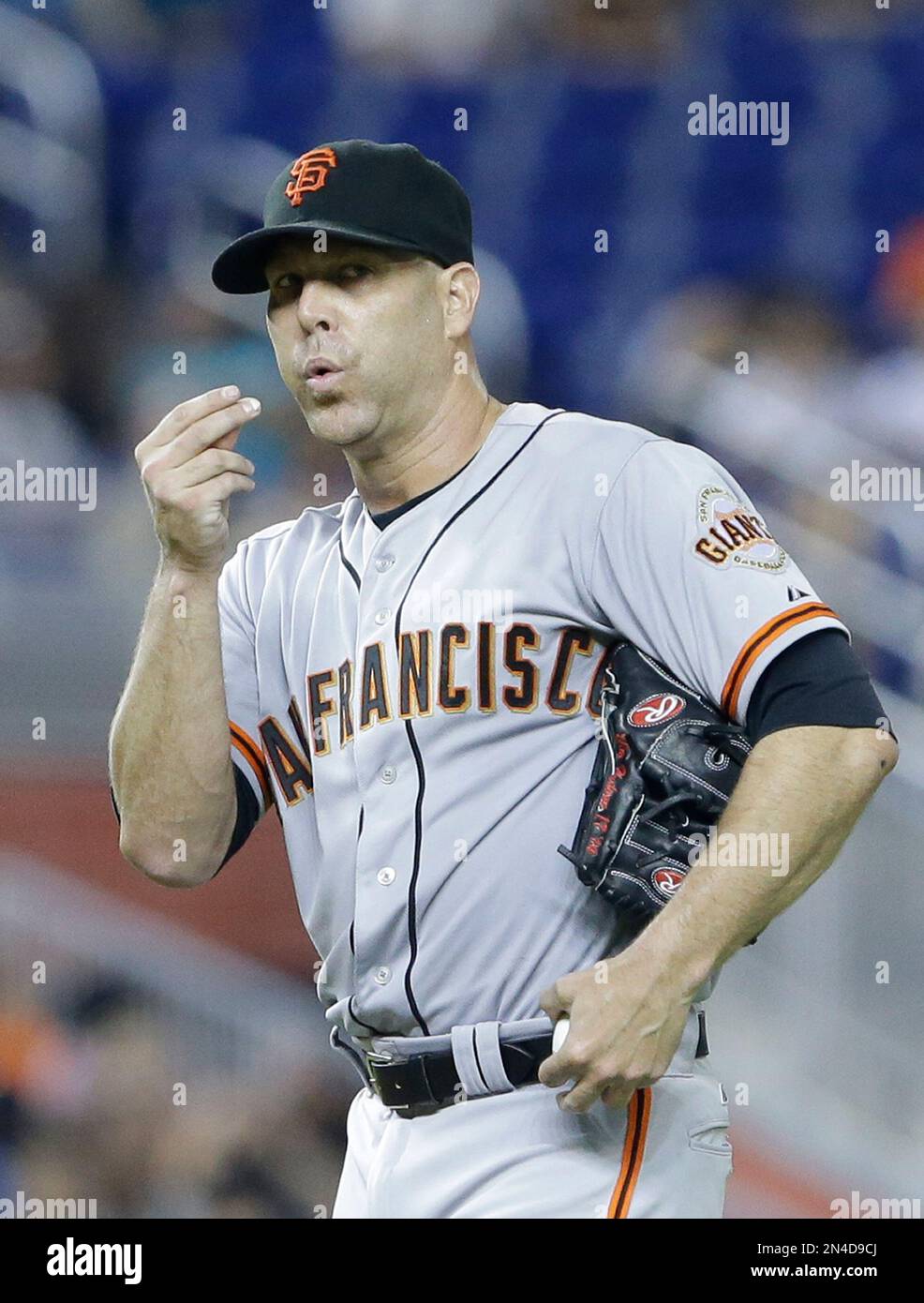 San Francisco Giants starting pitcher Tim Hudson blows on his fingers ...