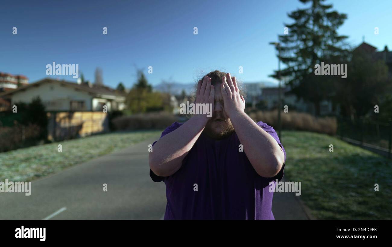 One angry overweight man walking outside. An upset young pensive person ...