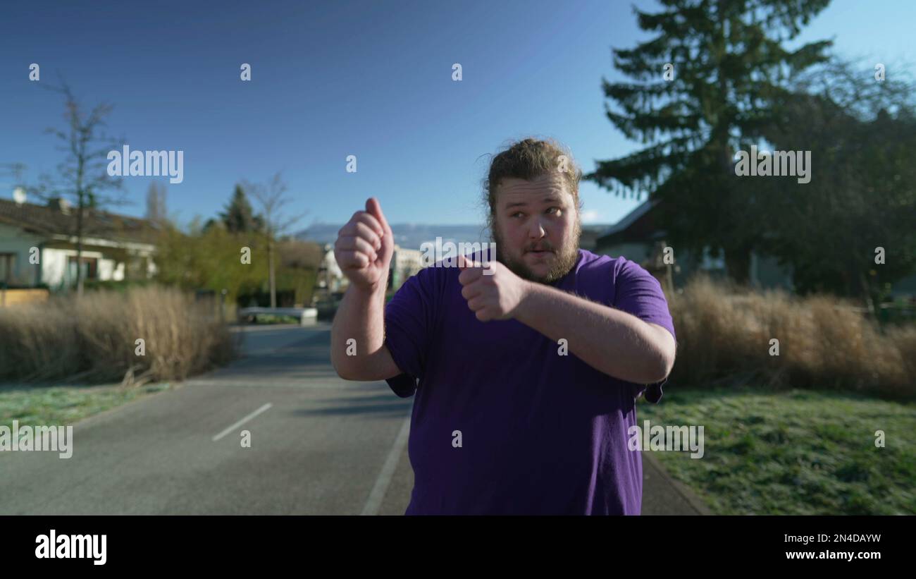 One happy fat man dancing and singing walking outside in street. A ...