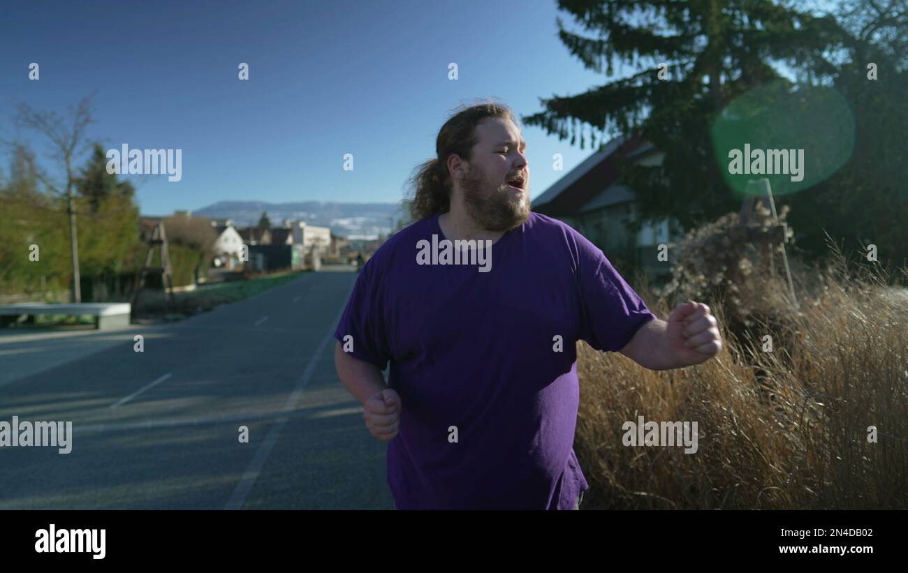 One happy fat man dancing and singing walking outside in street. A ...