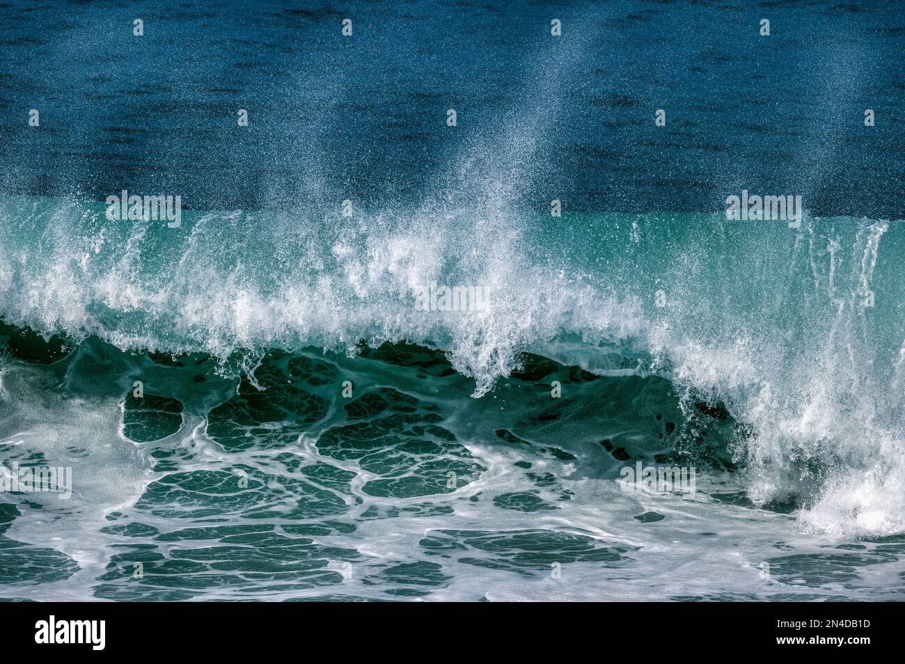 An Big Ocean Wave Is Breaking With White Spray At The Top Stock Photo ...
