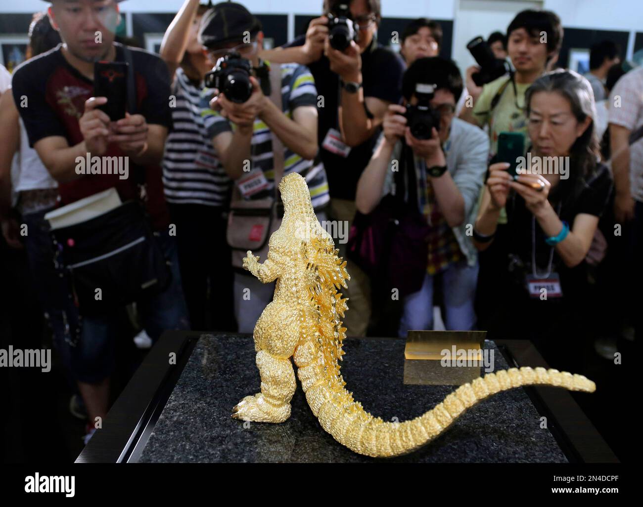 The golden statue of Godzilla is on display during a press preview at ...