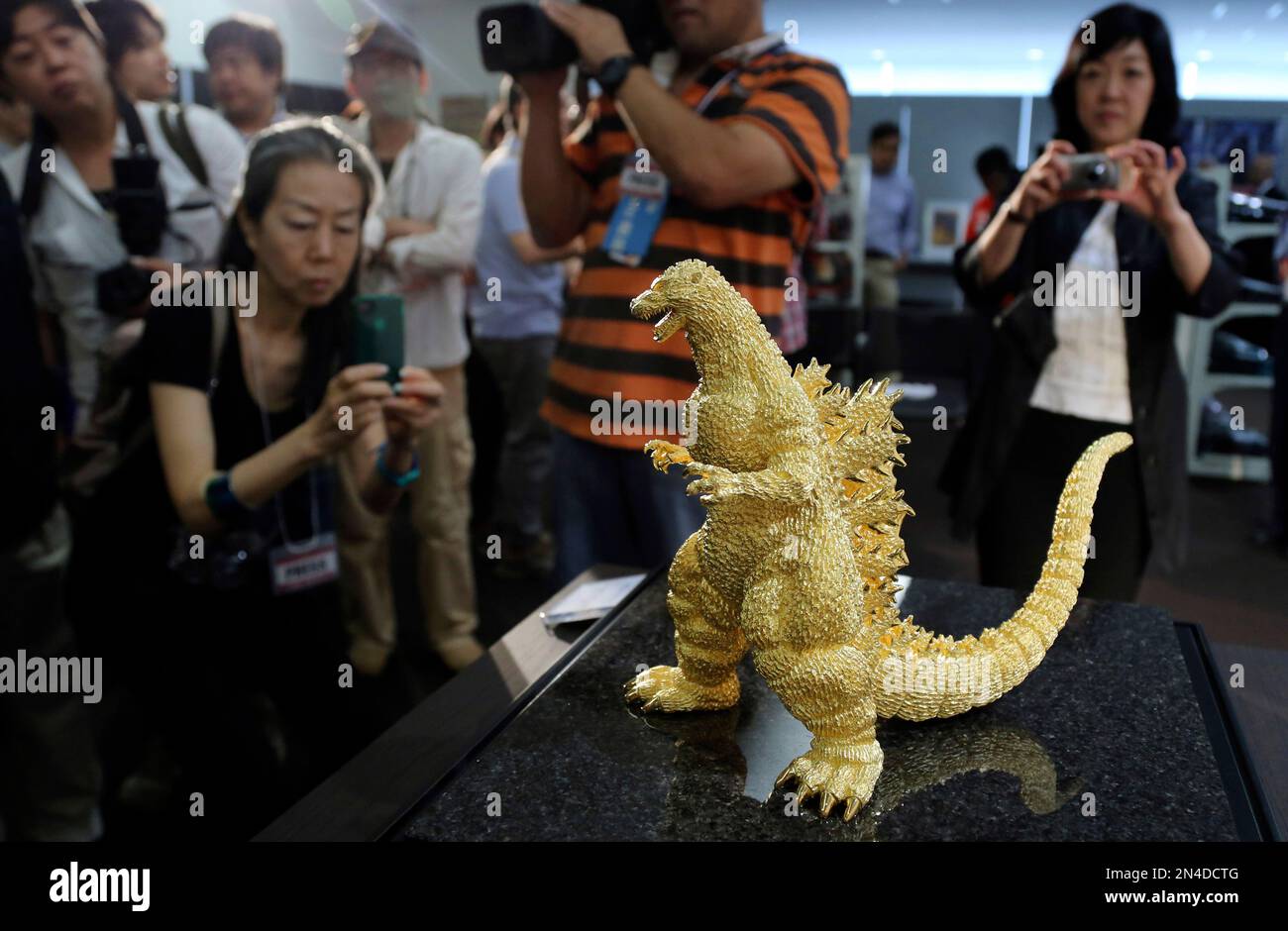 The golden statue of Godzilla is on display during a press preview at ...