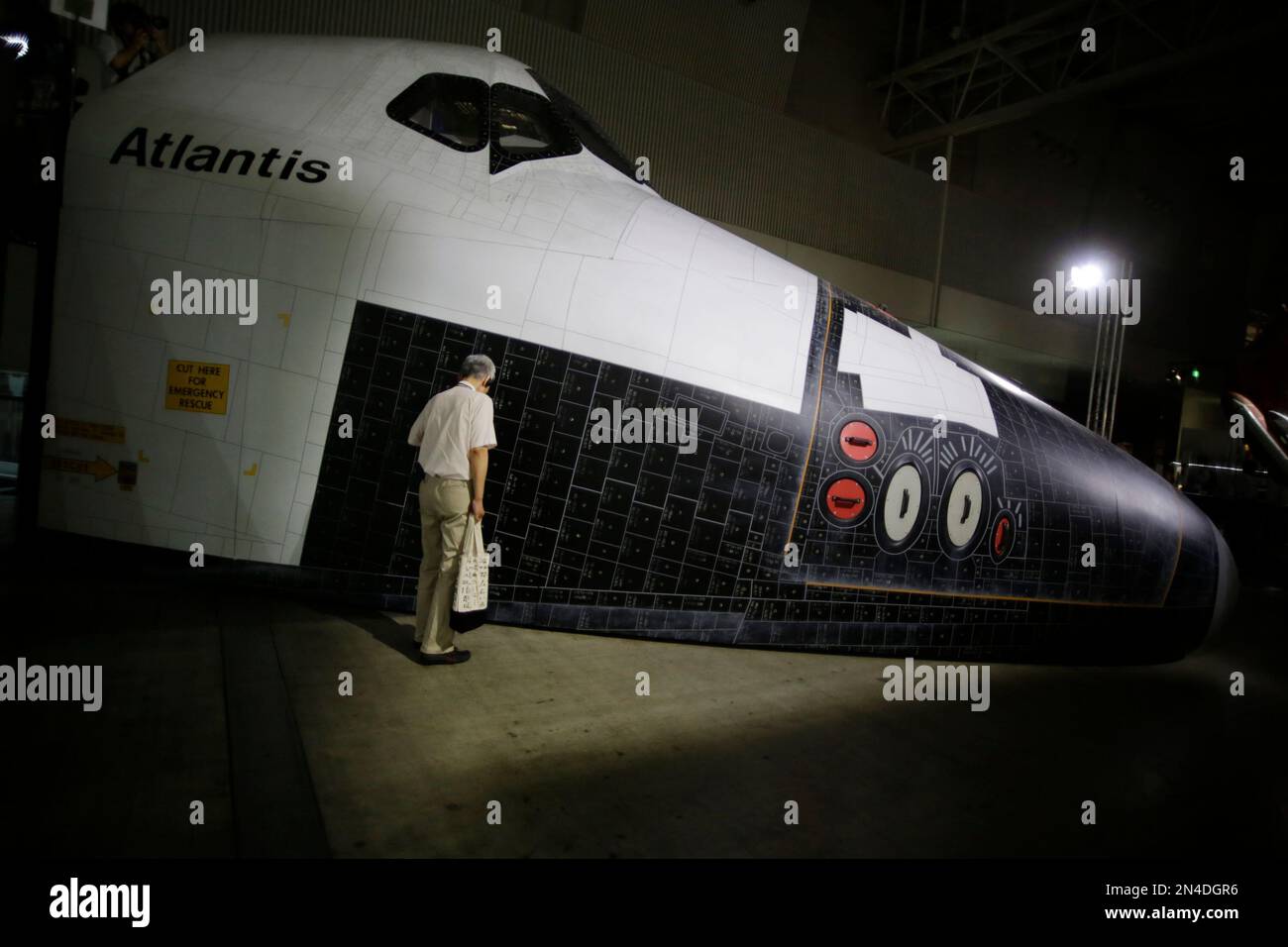 A visitor looks at a life-size model of NASA's Atlantis space shuttle ...