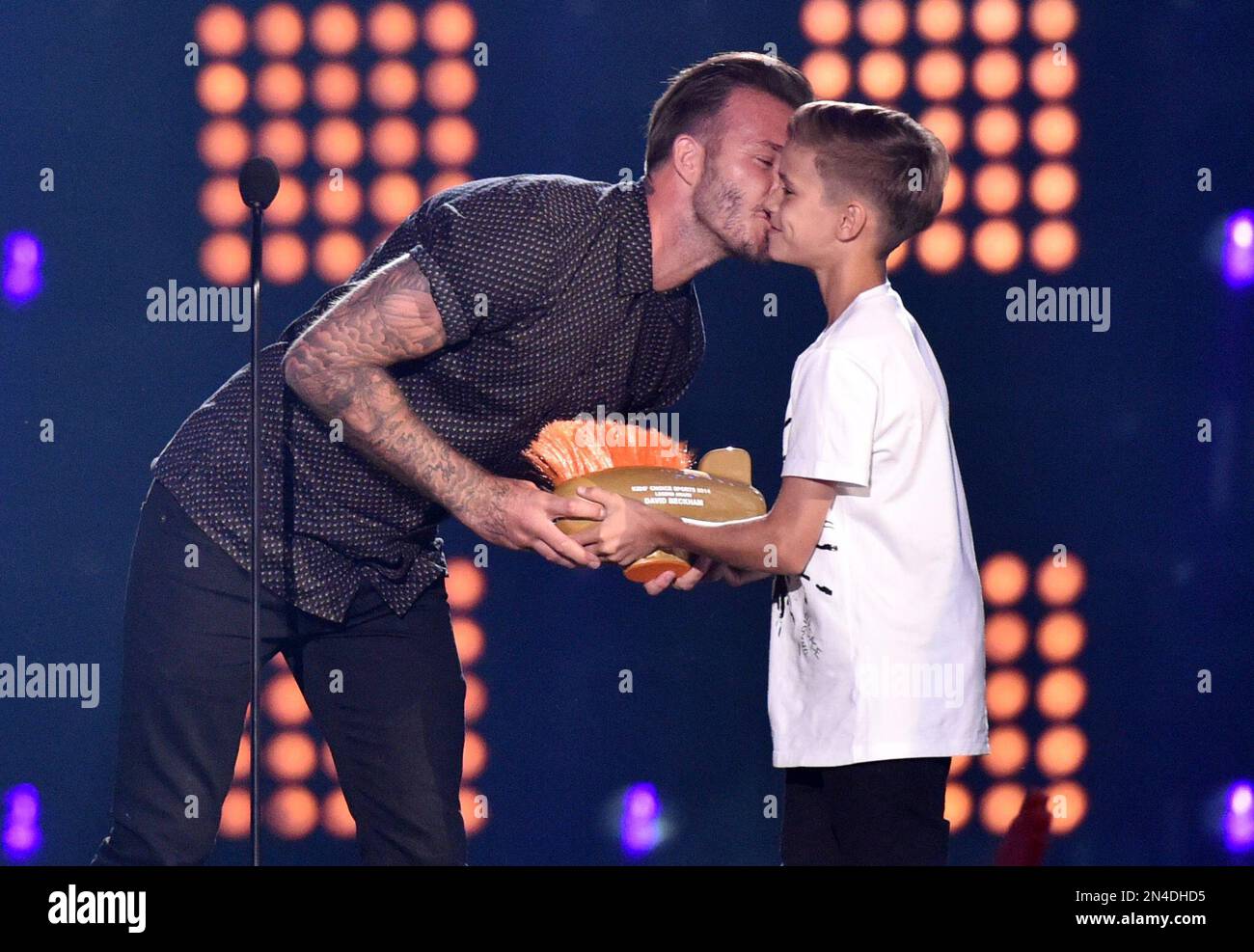 David Beckham, left, kisses his son Romeo James Beckham as he accepts ...