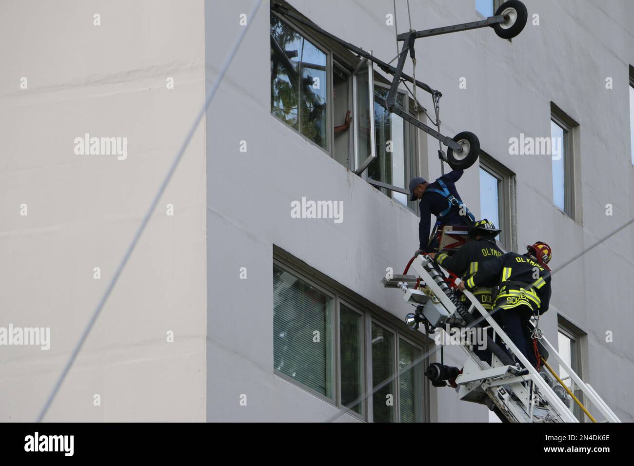 Firefighters use their ladder truck to reach a second window washer who ...