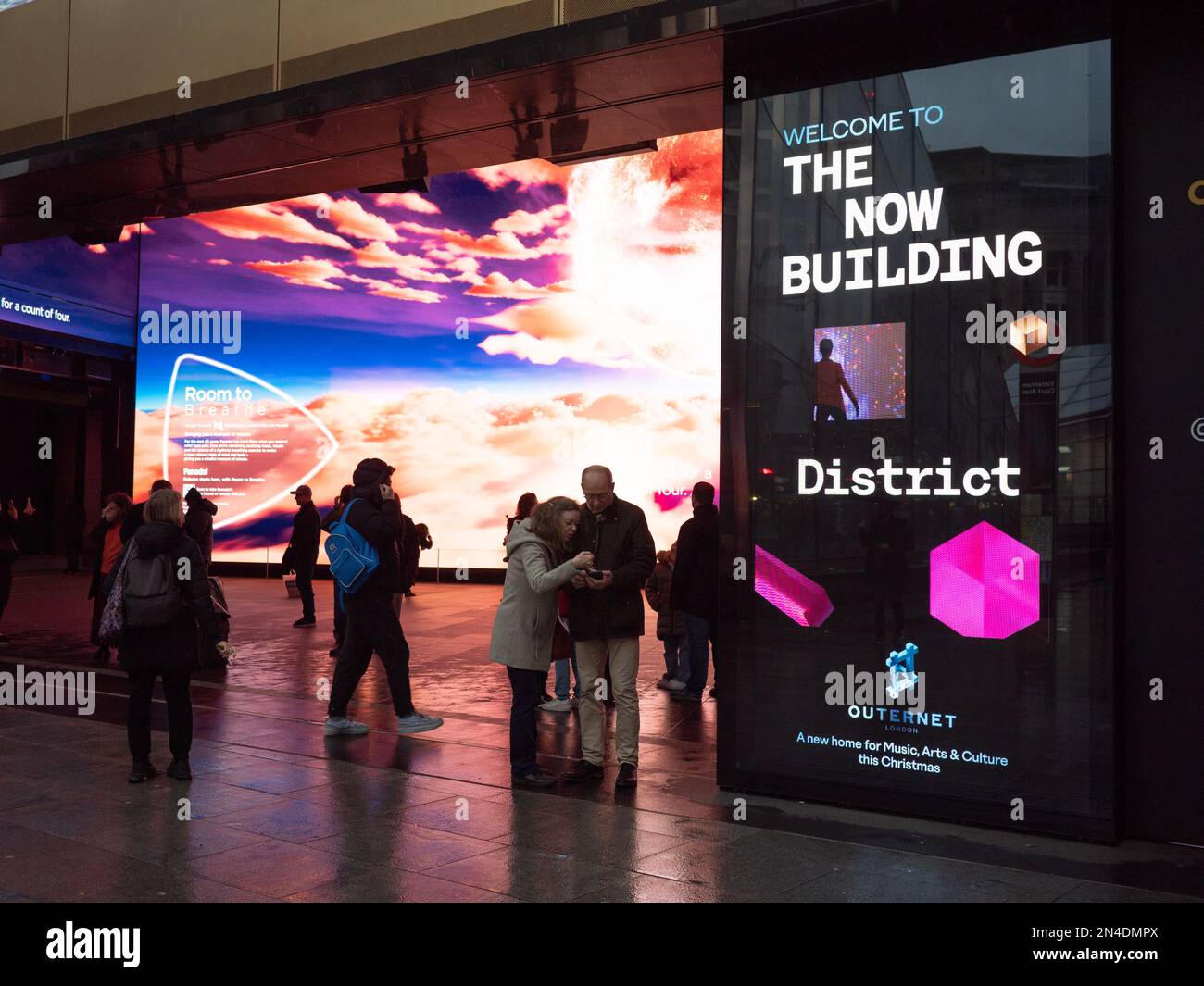 The now building. Members of the public look at huge screens ...