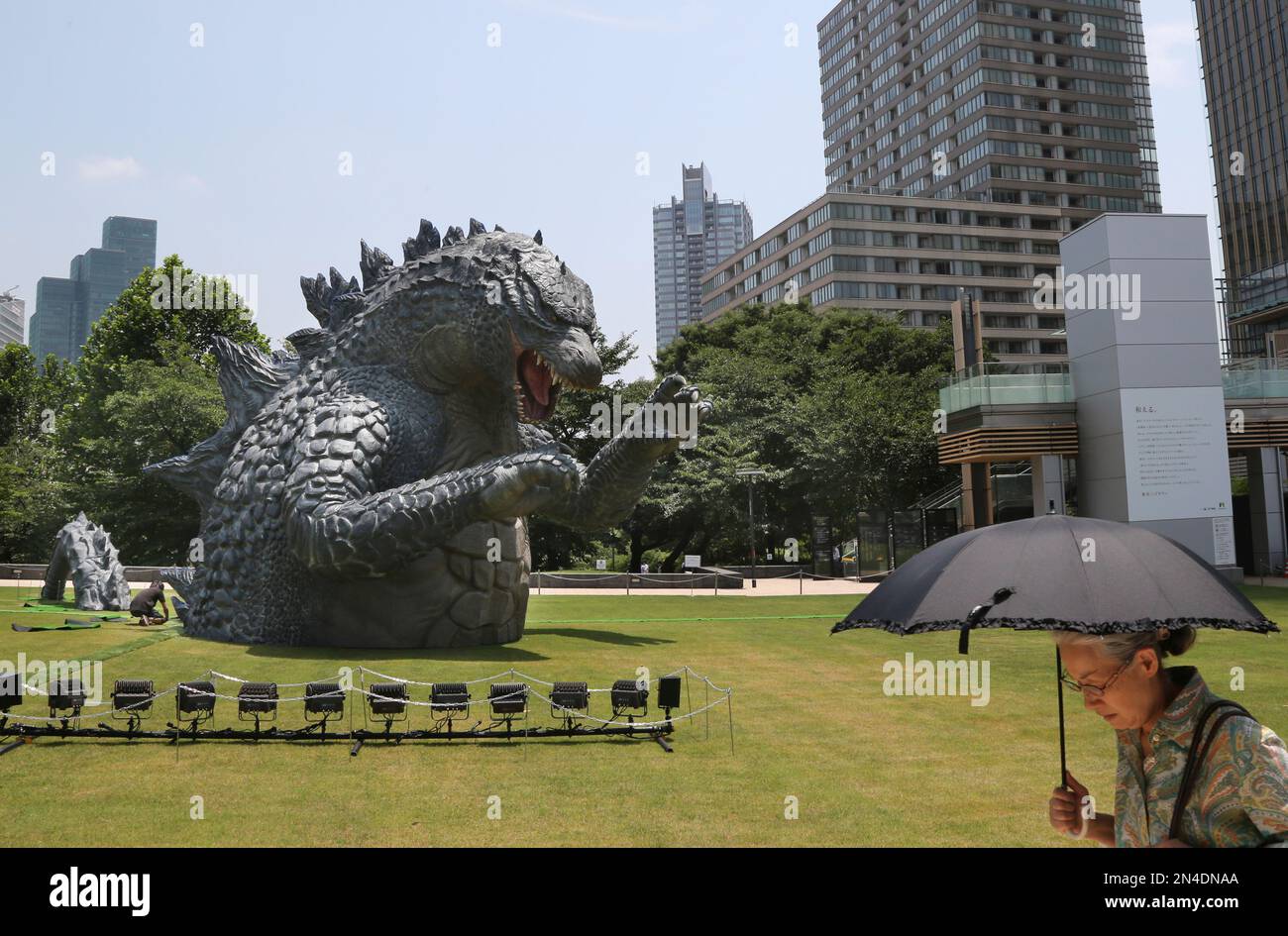 A woman walks past a scaled down model of the new "Godzilla," at Tokyo ...
