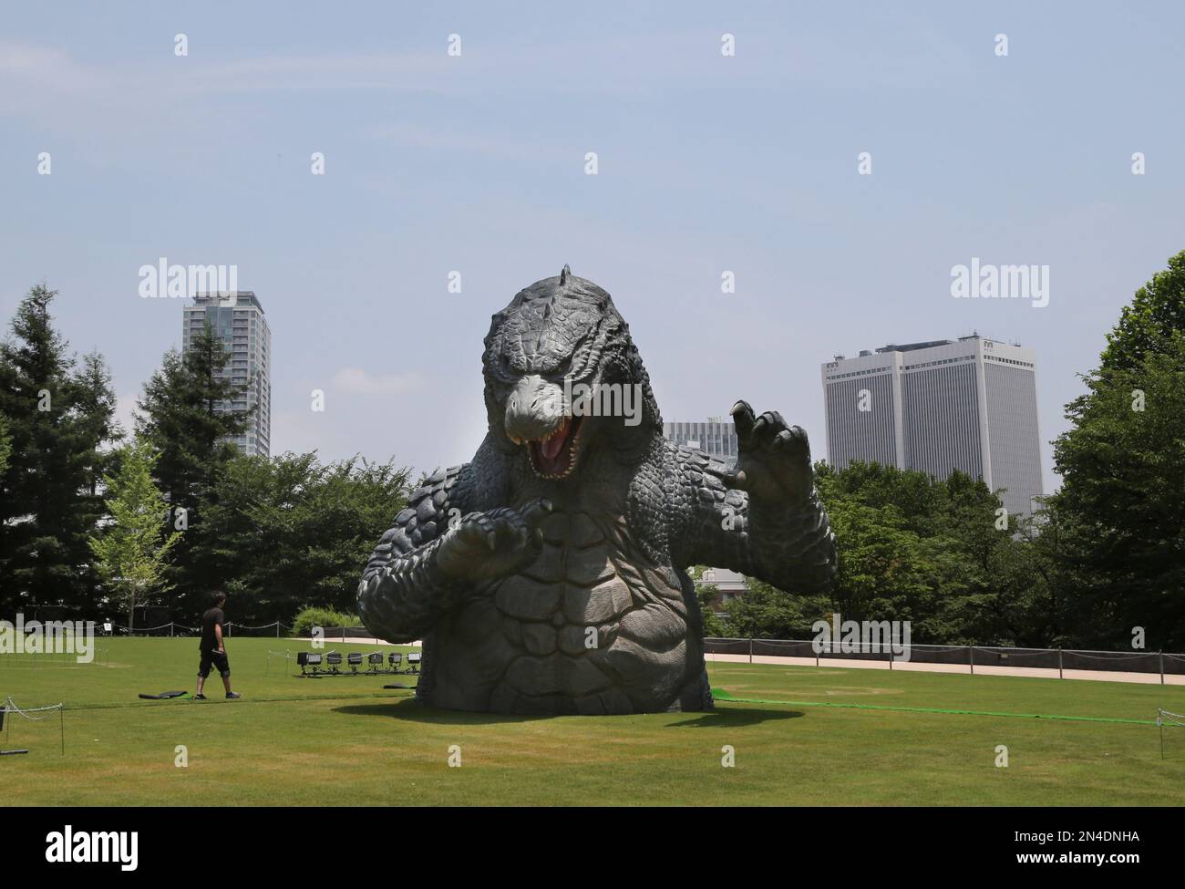 A scaled down model of the new "Godzilla," dwarfs a worker at Tokyo ...