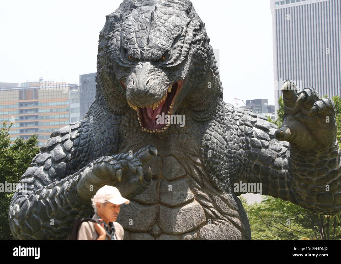 A man walks past a scaled down model of the new "Godzilla," at Tokyo ...