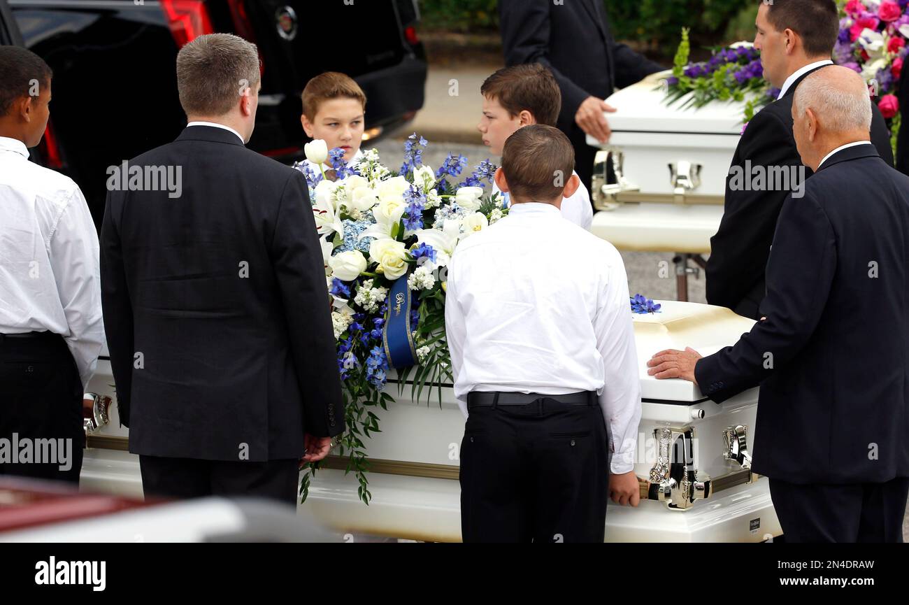 Children help as pallbearers to load the caskets after a funeral ...