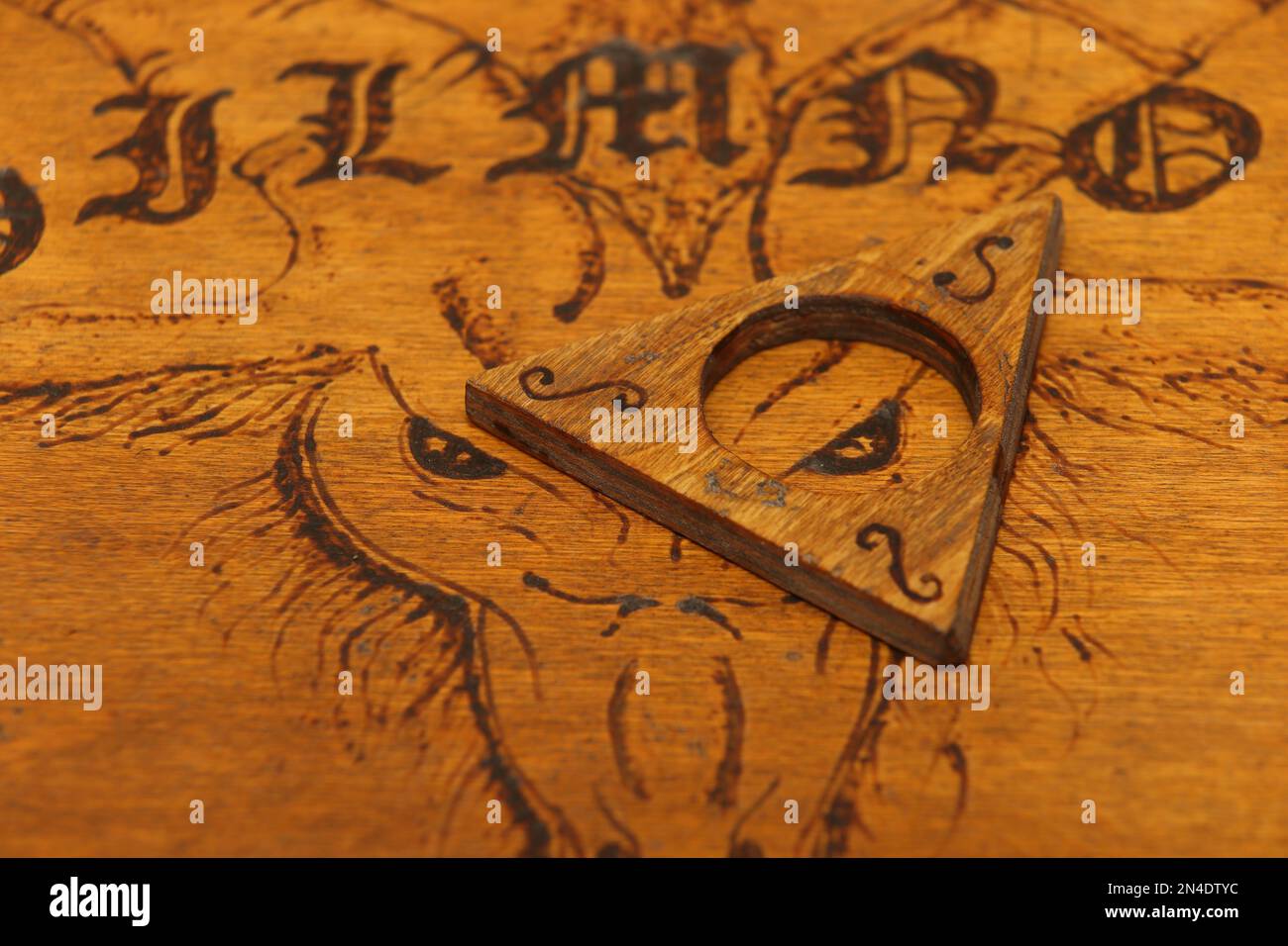 ouija board in pyrographed wood Stock Photo - Alamy