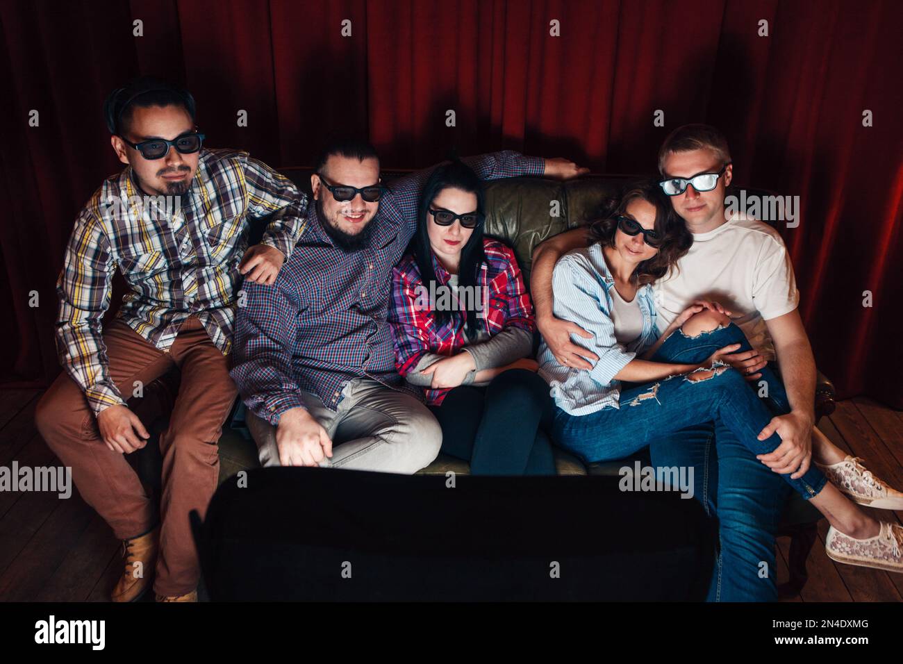 Company of young happy people watch tv at home Stock Photo - Alamy