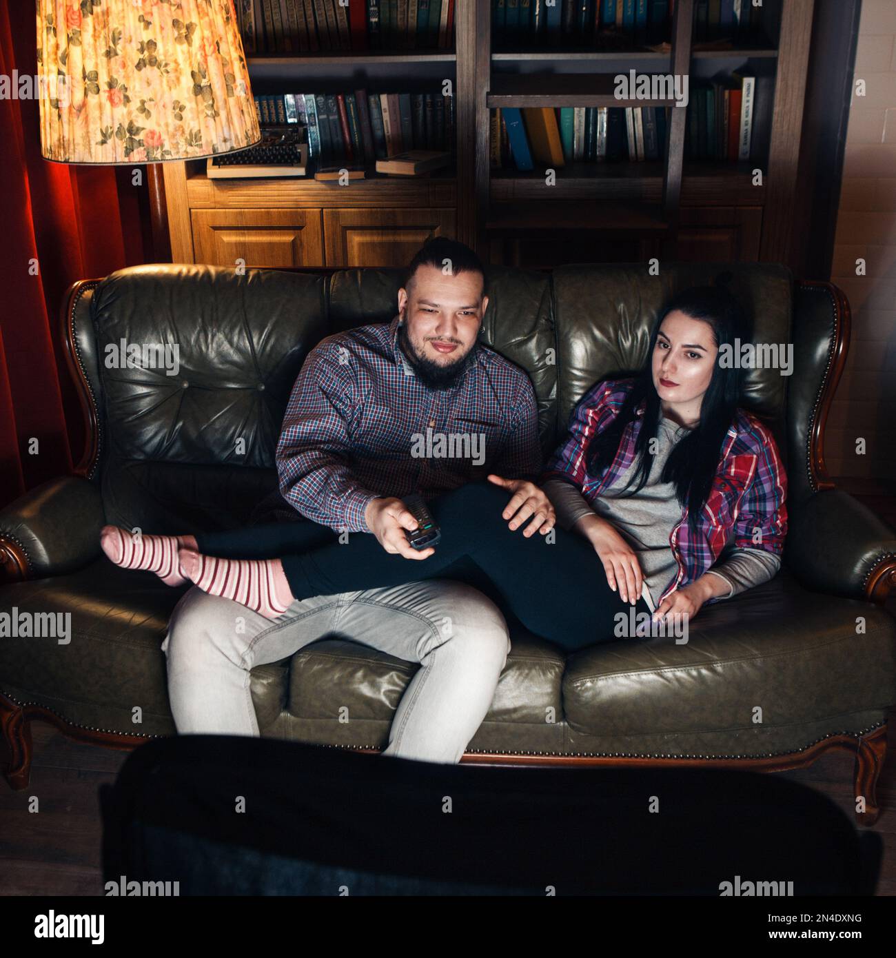 Young couple addicted to tv. Bad habit problem Stock Photo - Alamy
