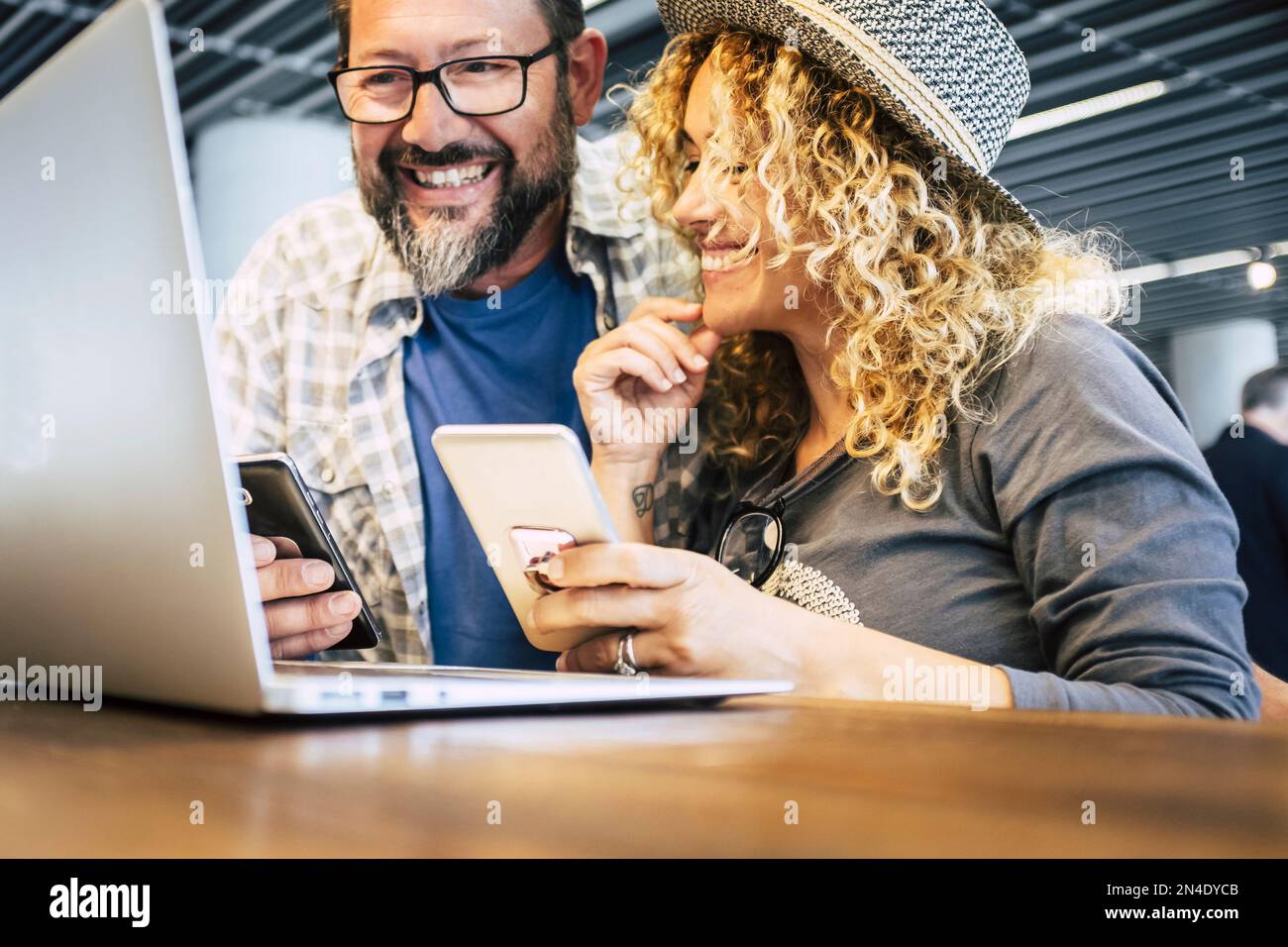 Modern happy youth couple working together with smartphone and laptop ...