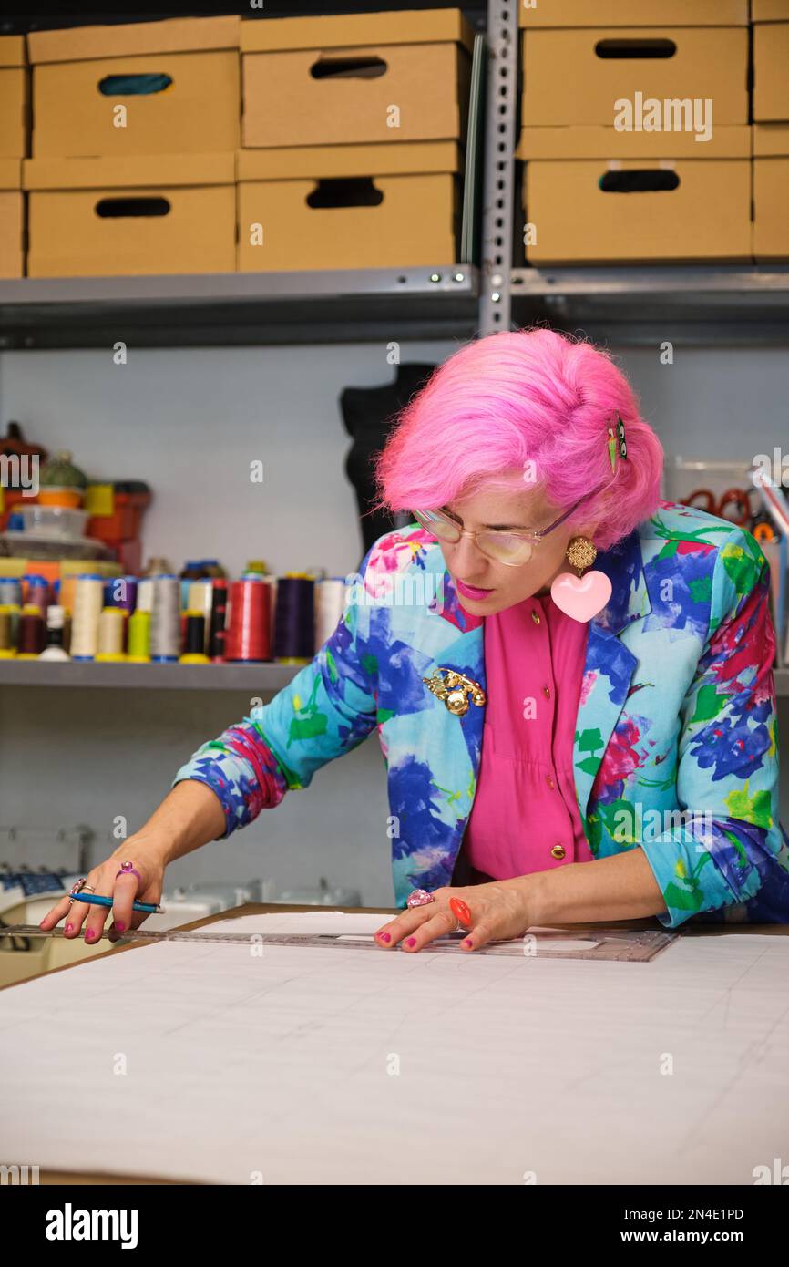 Seamstress with pink hair and colorfull clothes drawing sewing patterns ...