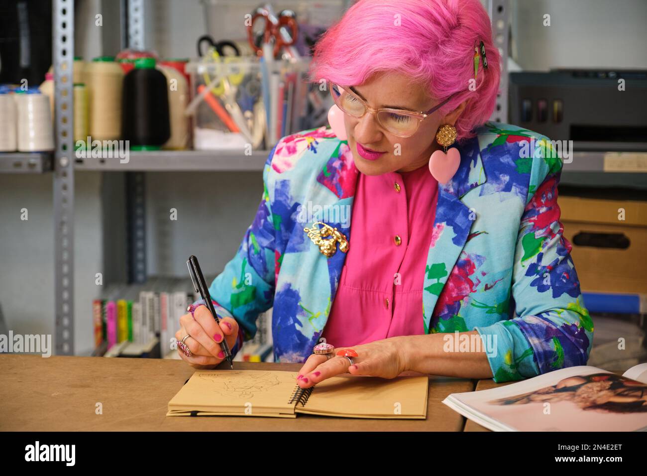 Seamstress with pink hair and colorfull clothes drawing new layout ...