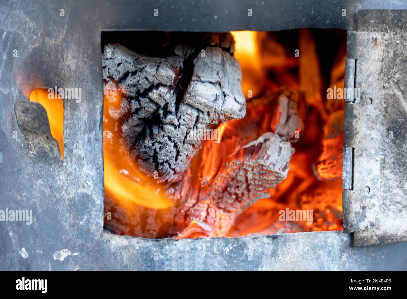 Fire burning in small black iron stove. Closeup photo with selective ...