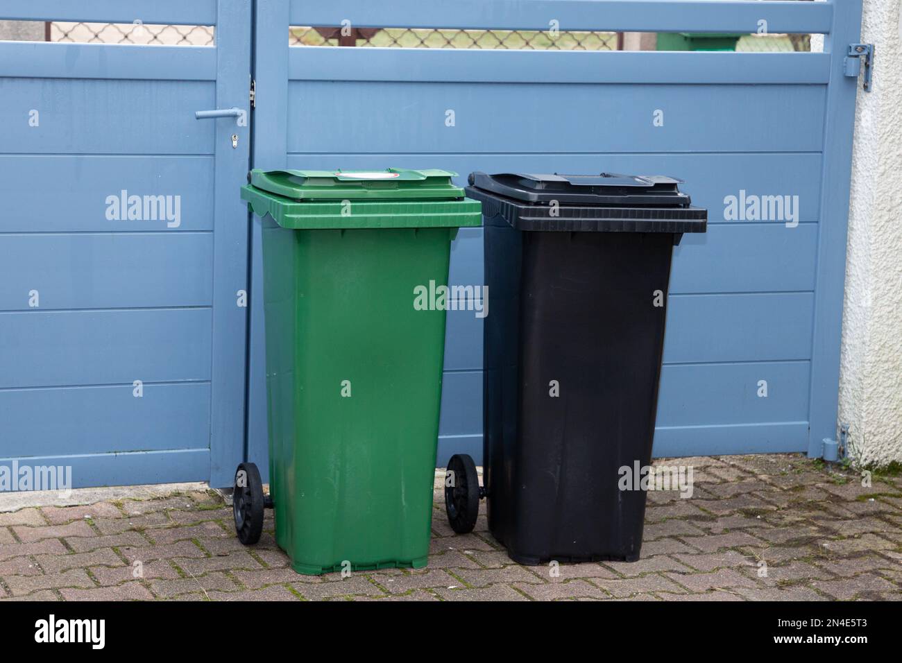 Two large outdoor grey and green garbage bin in home garden Stock Photo ...