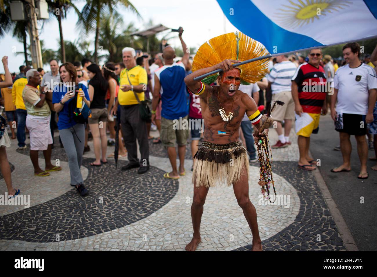 A performer dressed in an Amazonian Indian costume holds an Argentine ...