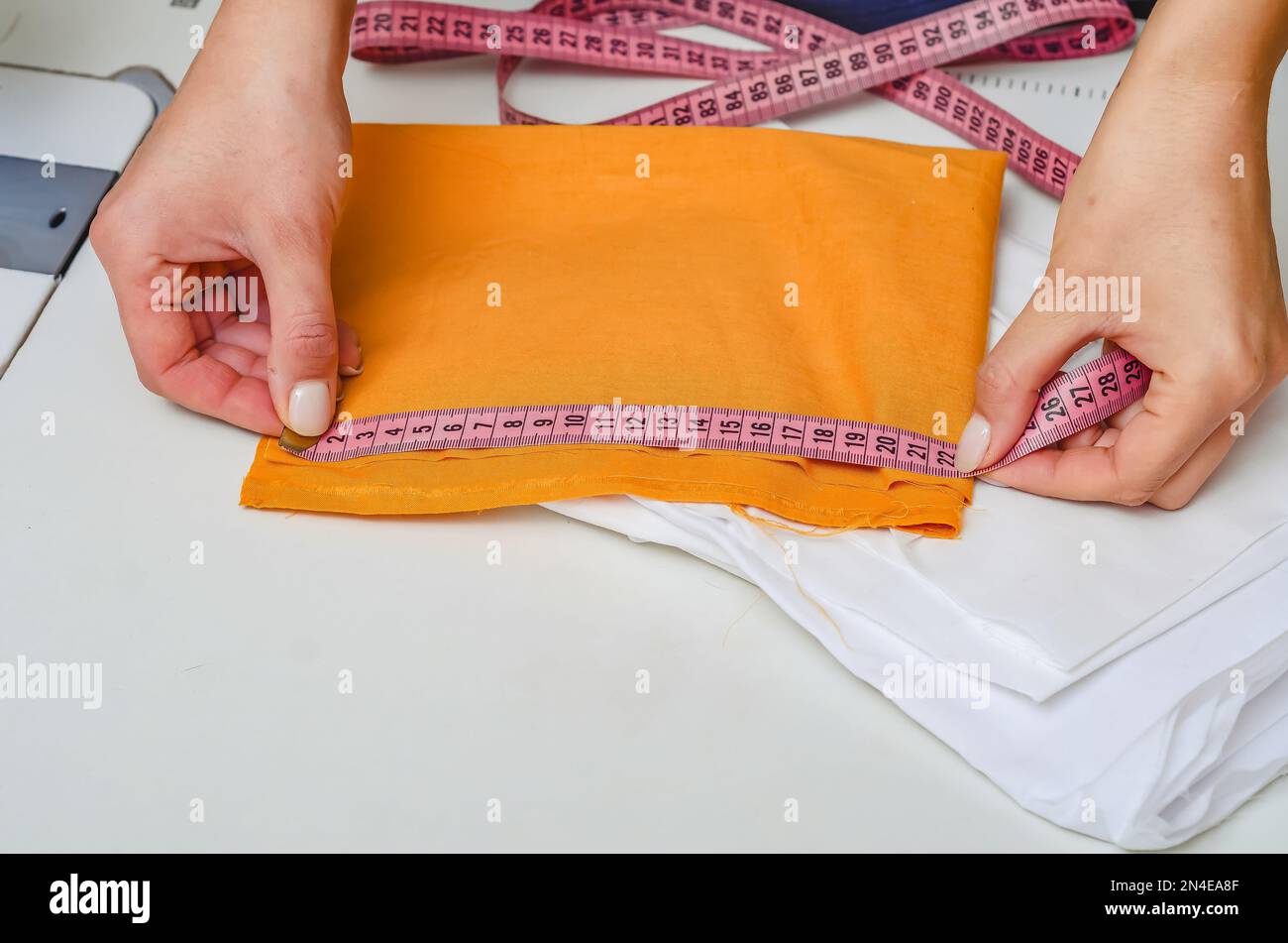 Dressmaker measures the cloth for sewing clothes with measuring tape ...