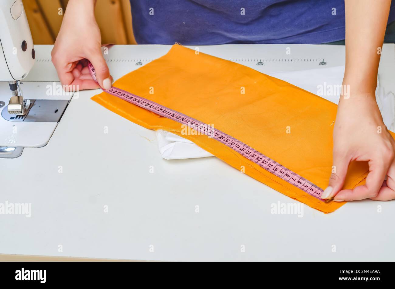 Dressmaker measures the cloth for sewing clothes with measuring tape ...