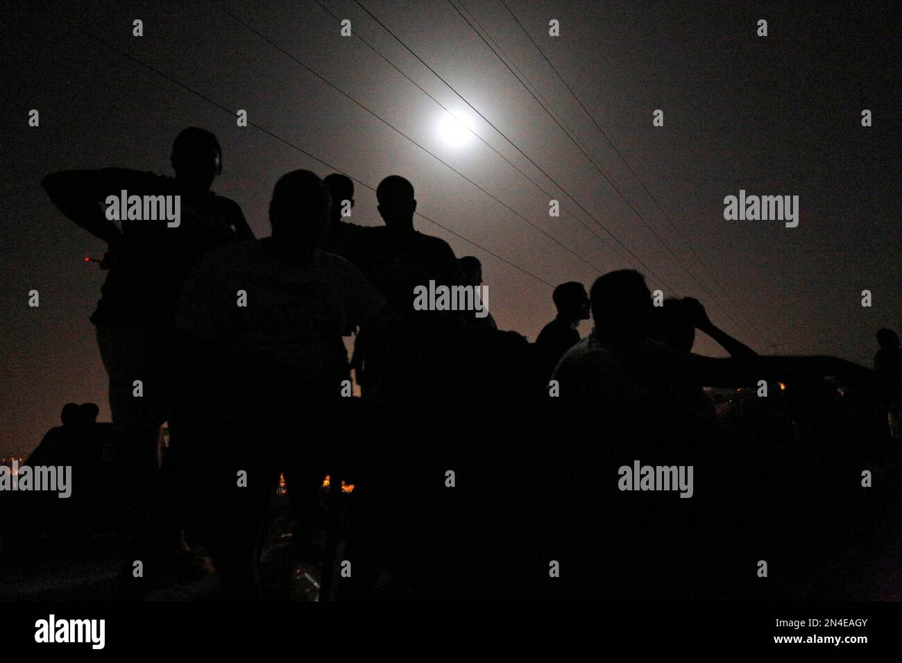 A perigee moon, also known as a supermoon, is seen behind Israelis ...