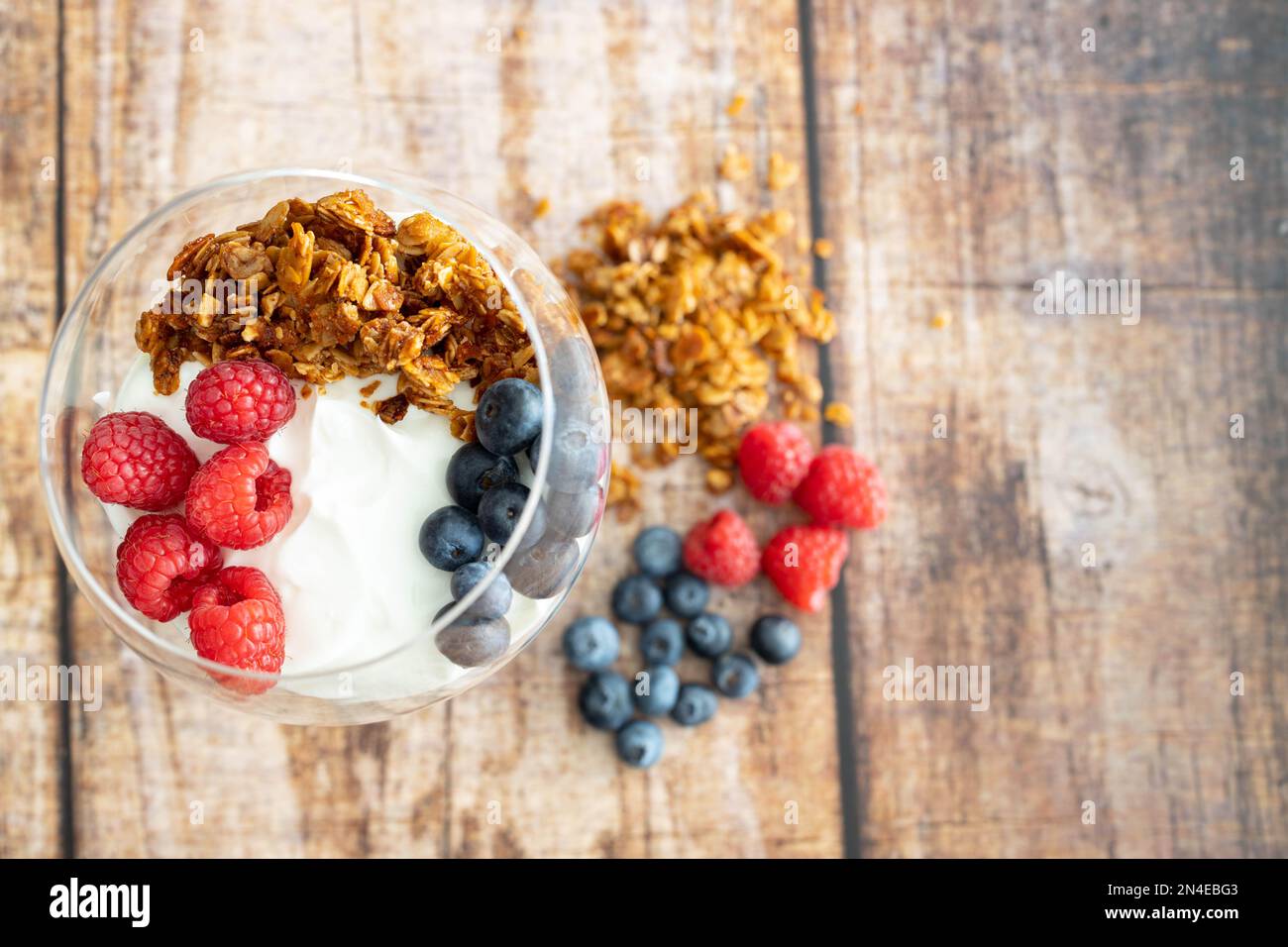 granola with raspberries and blueberries with yogurt in a wine glass on ...
