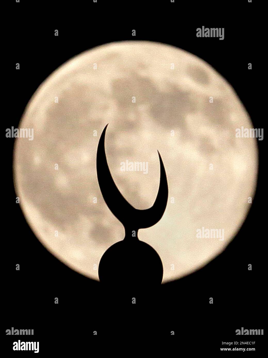 A perigee moon, also known as a supermoon, looks over a crescent of a ...