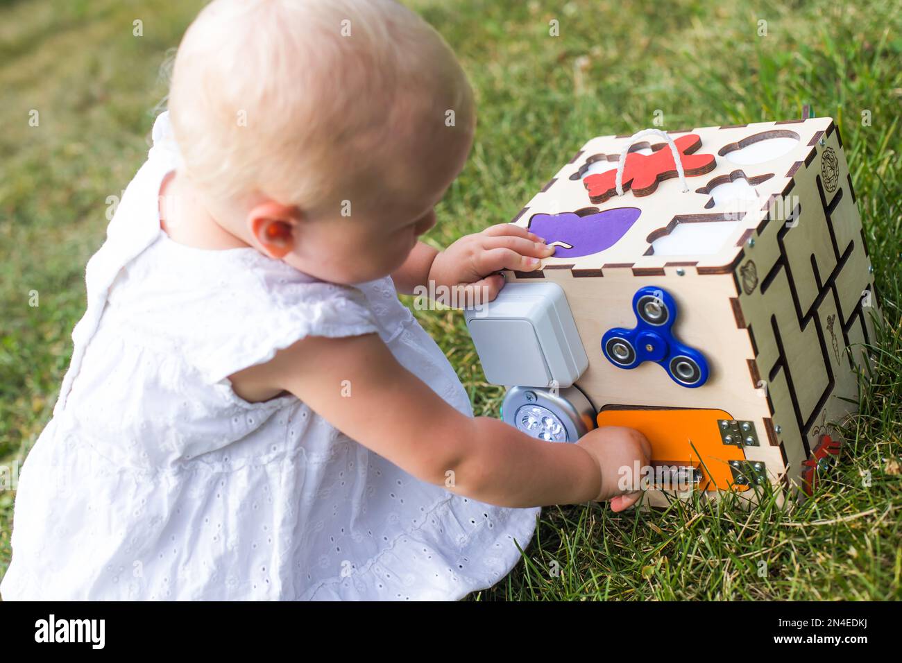 The child wants to open the door with a snap on the developing cube ...