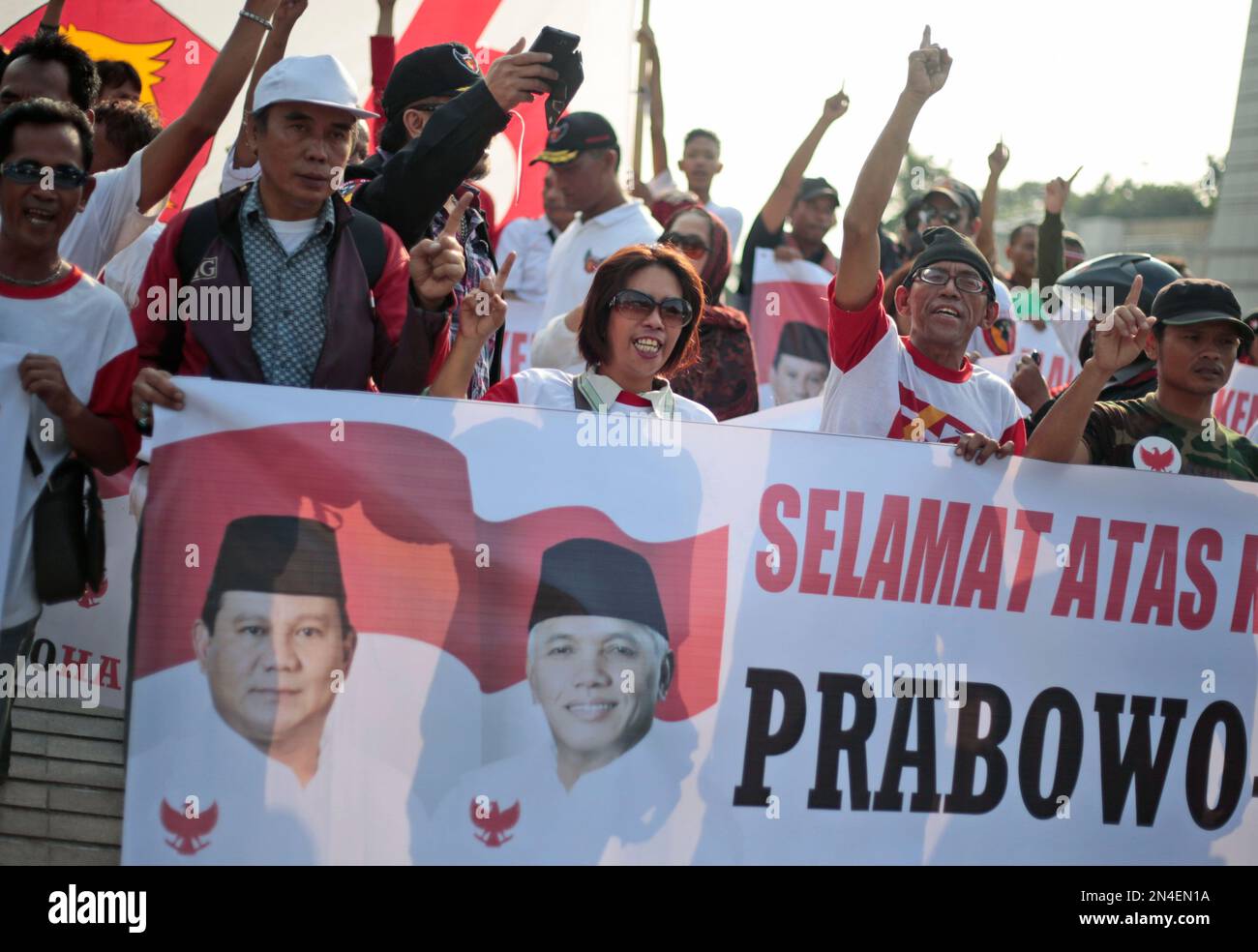 Supporters display a banner bearing a portrait of Indonesian ...