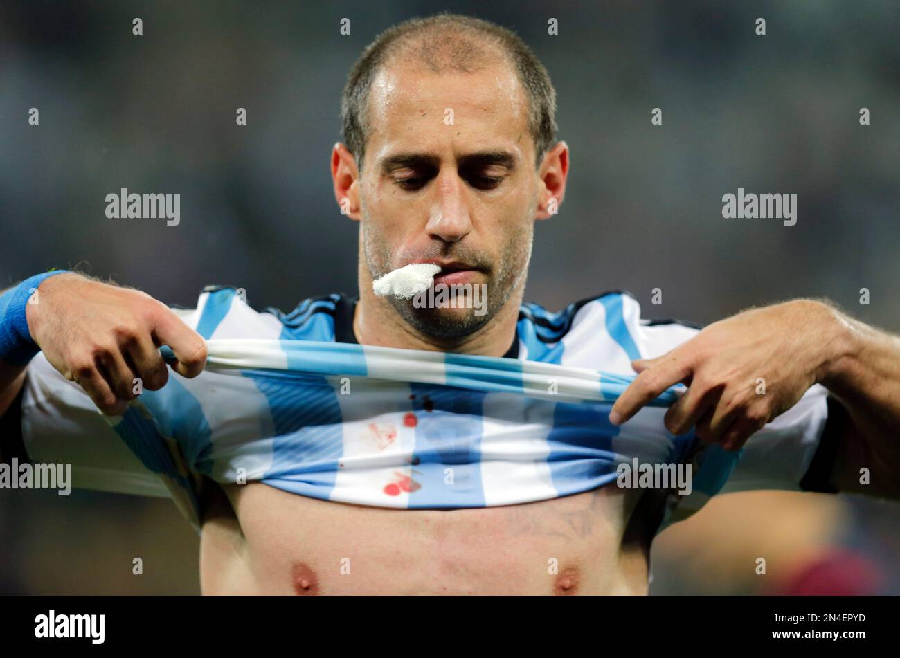 Argentina's Pablo Zabaleta changes his shirt after colliding with a ...