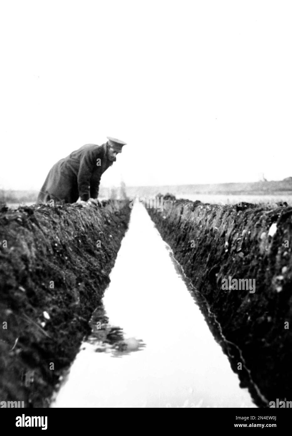 A soldier looks into an abandoned trench in Flanders after its ...