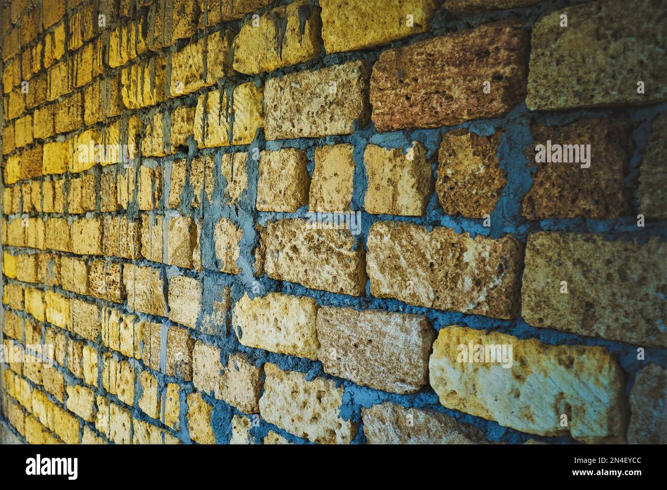 Old yellow wall of limestone with grey seams, perspective view Stock ...