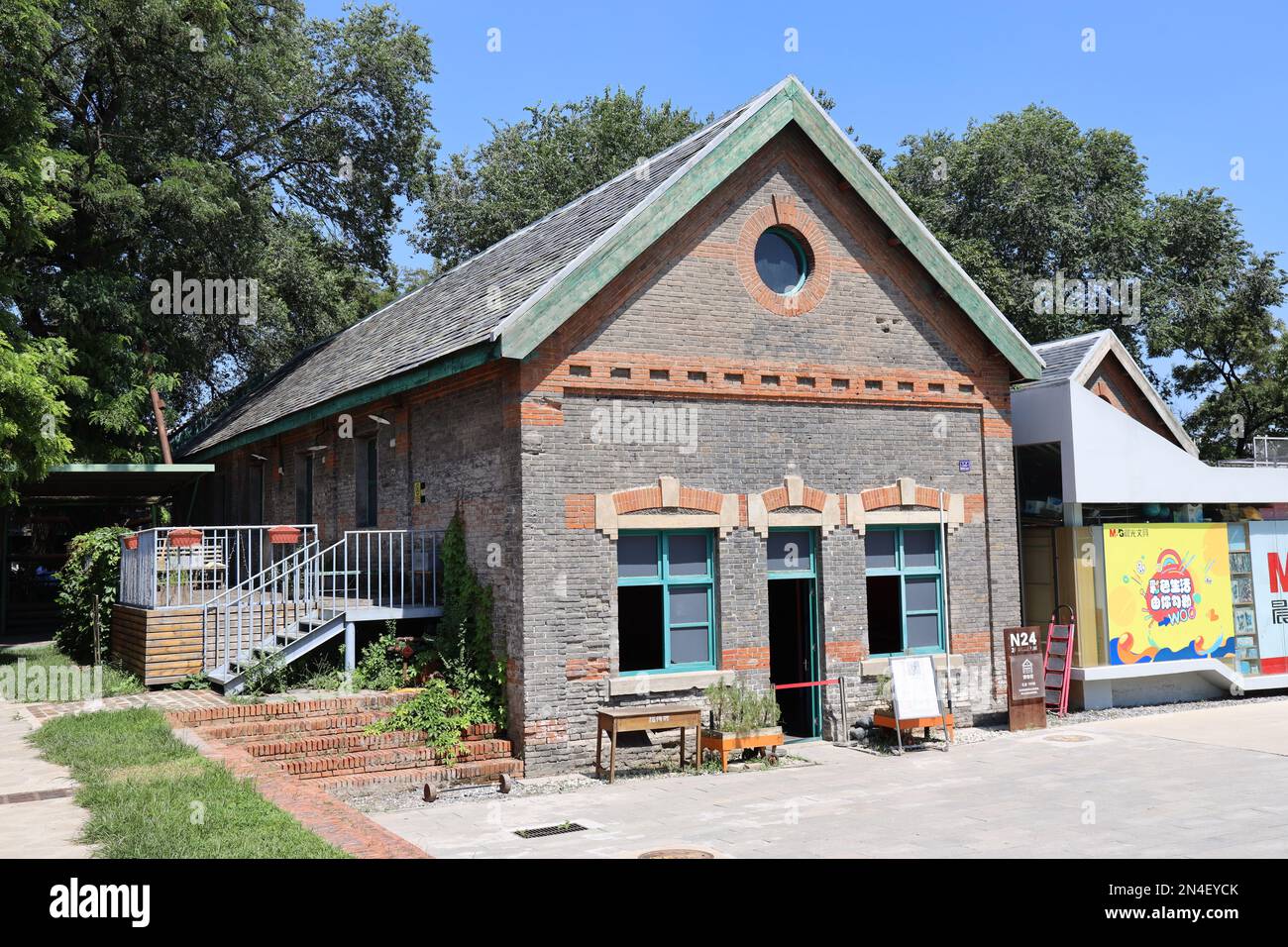 The facade of a small brick building with trees behind it on a sunny ...