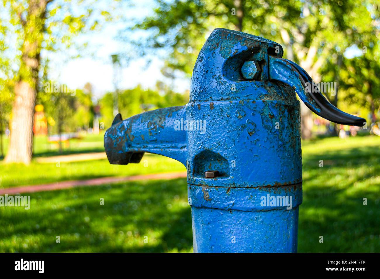 Old rusty blue outdoor well in a green park Stock Photo - Alamy
