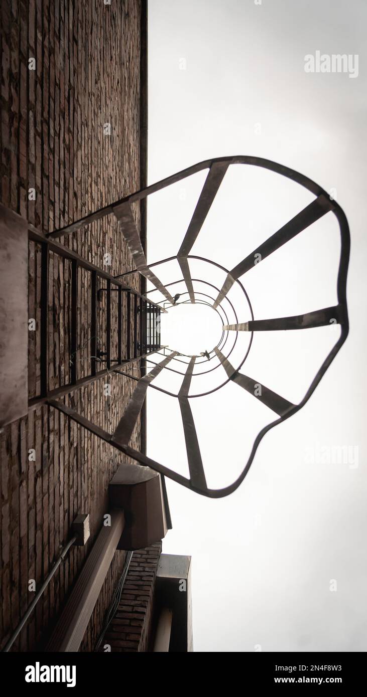 A vertical low angle shot of a fire escape stairway on the outside of a ...