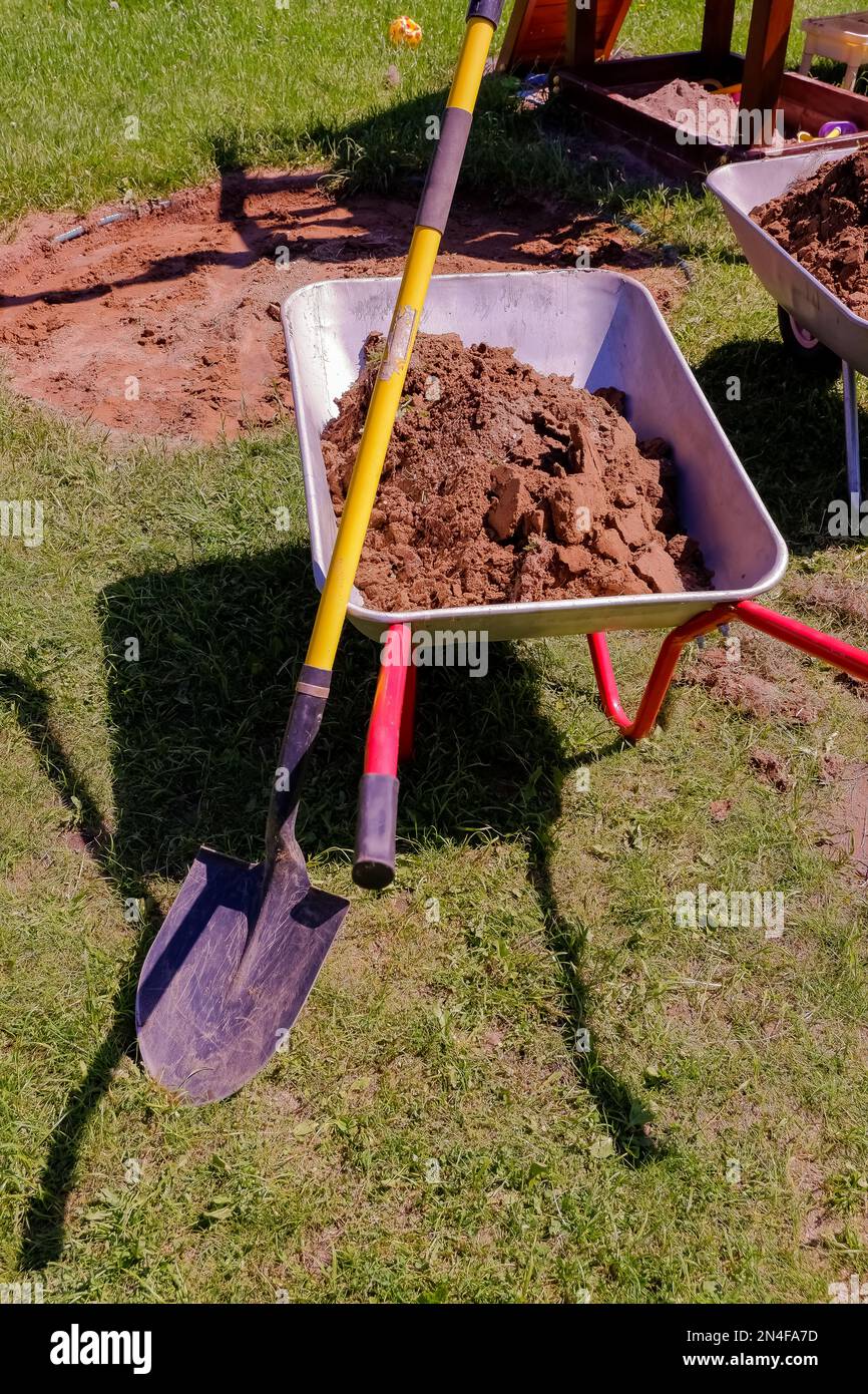 Garden trolley with soil on the lawn. Metal construction trolley for ...