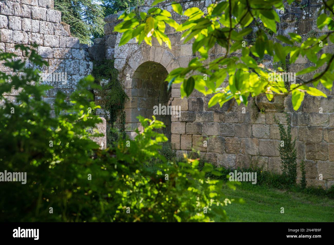 An ancient stone arch framed by trees at Jervaulx Abbey, a grade 1 ...