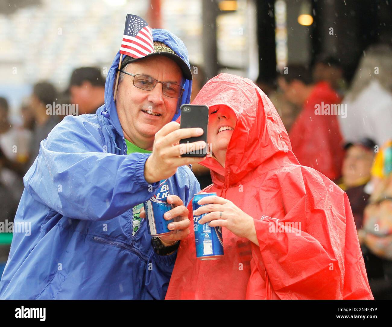 Race fans make a selfie photo in the Fan Zone during a rain shower ...